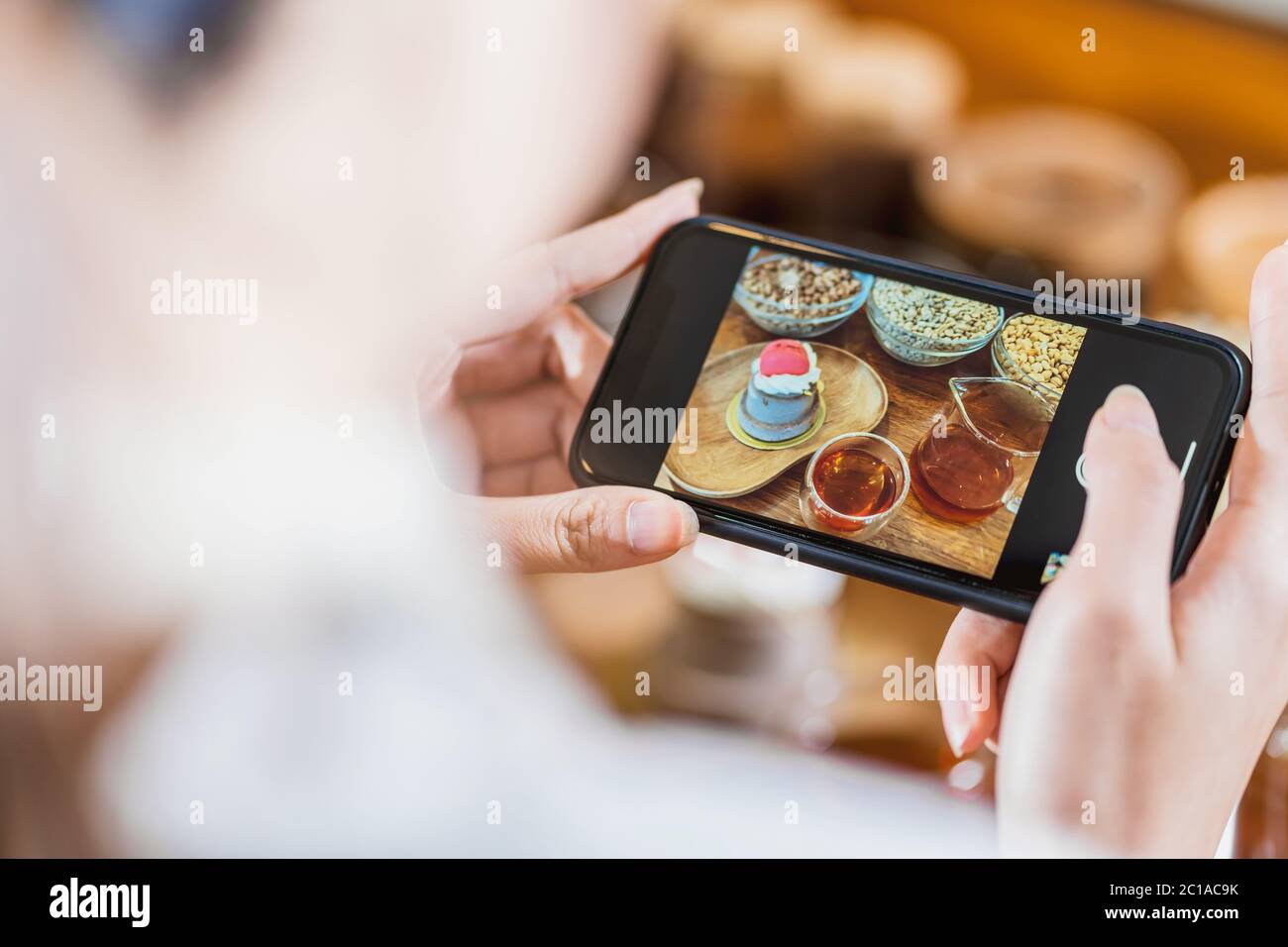 Closeup mobile phone taking photo of cupcake bakery with honey serving ...