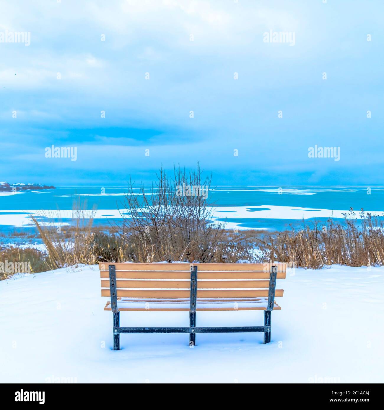 Square frame Bench overlooking semi frozen Utah Lake with overcast sky ...