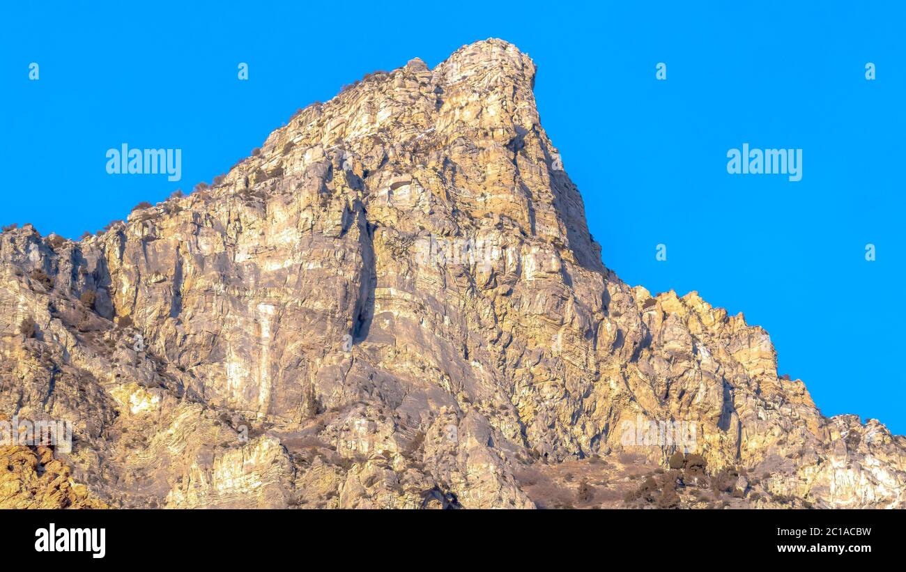 Panorama frame Precipitous slope of a rocky mountain gainst clear blue ...