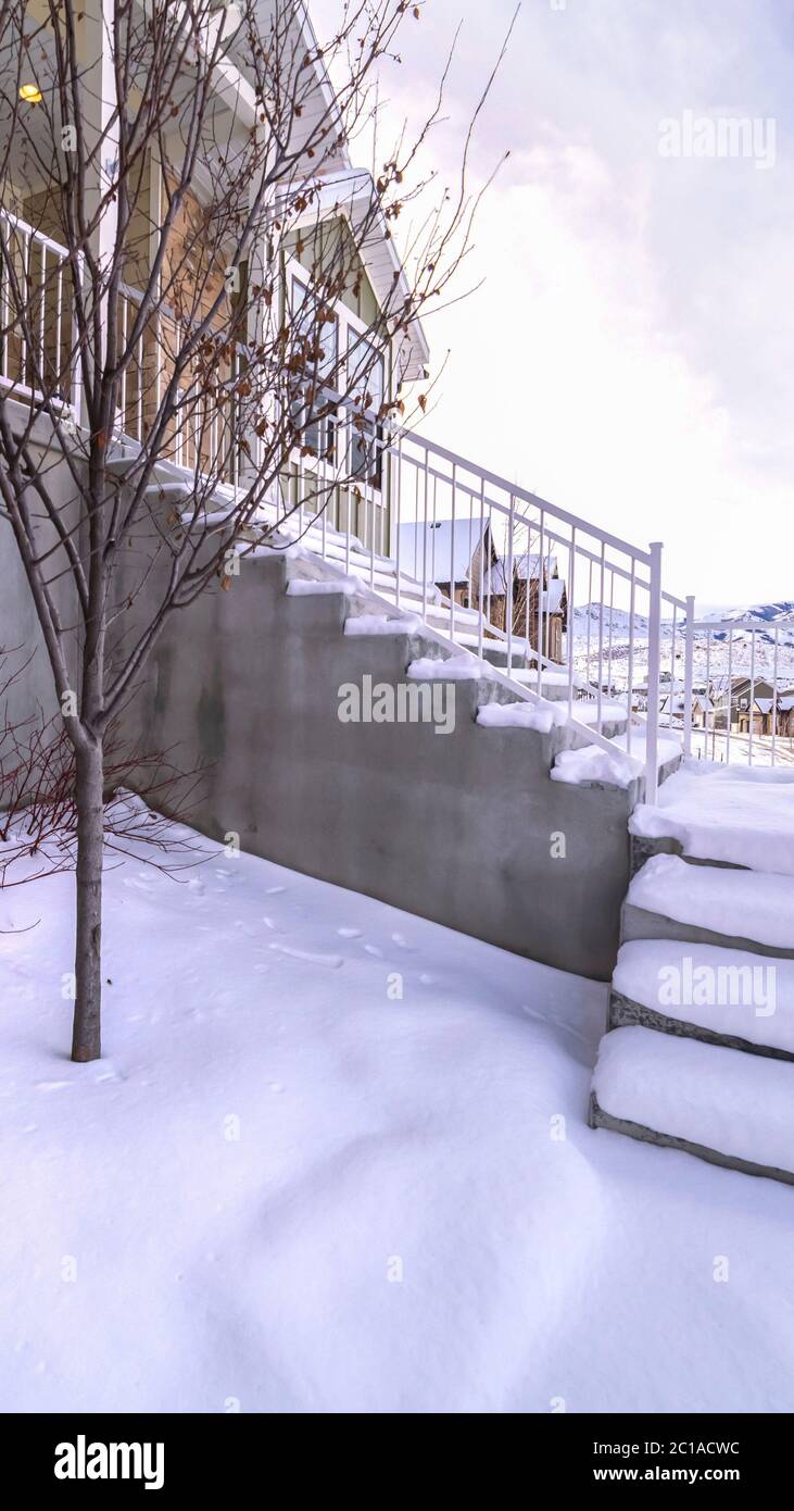 Vertical crop Snow covered concrete exterior entrance steps day light ...