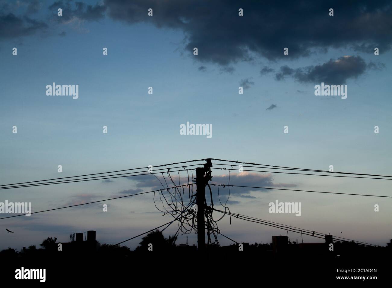 clutter electric pole with wires background dark clouds with sillhoutte ...