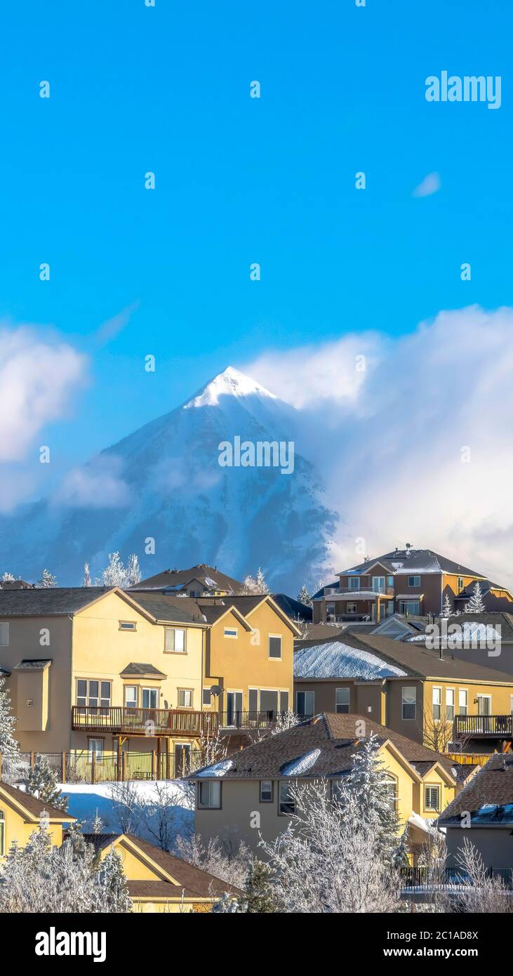 Vertical crop Homes on frosted neighborhood setting with view of snowy ...