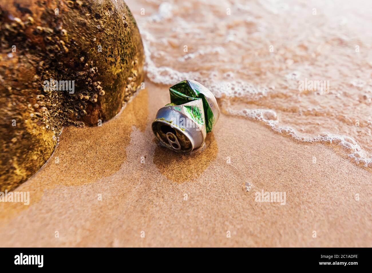 Beverage Can on the beach and water flow Stock Photo - Alamy