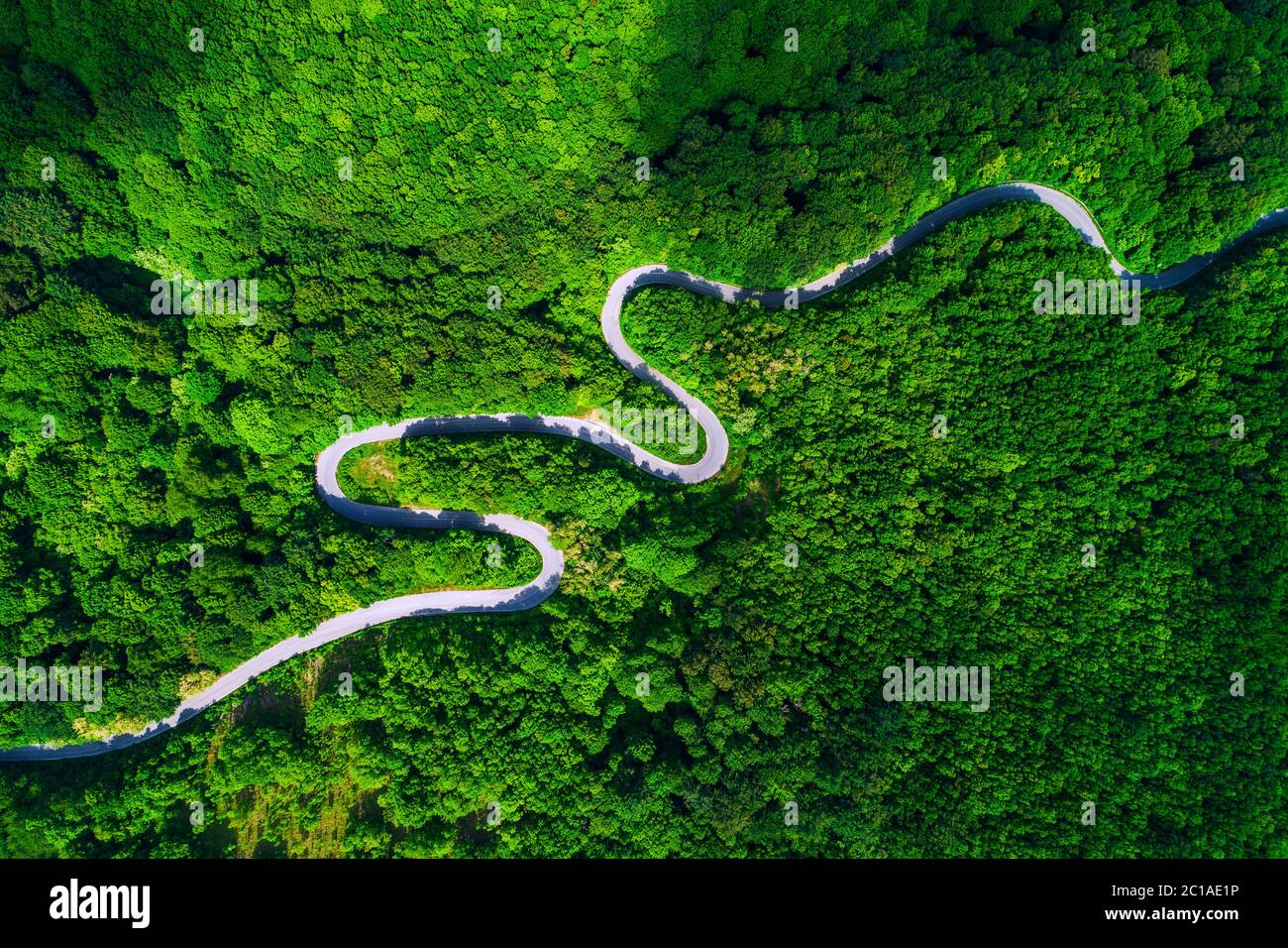 Aerial view over mountain road going through forest landscape Stock ...