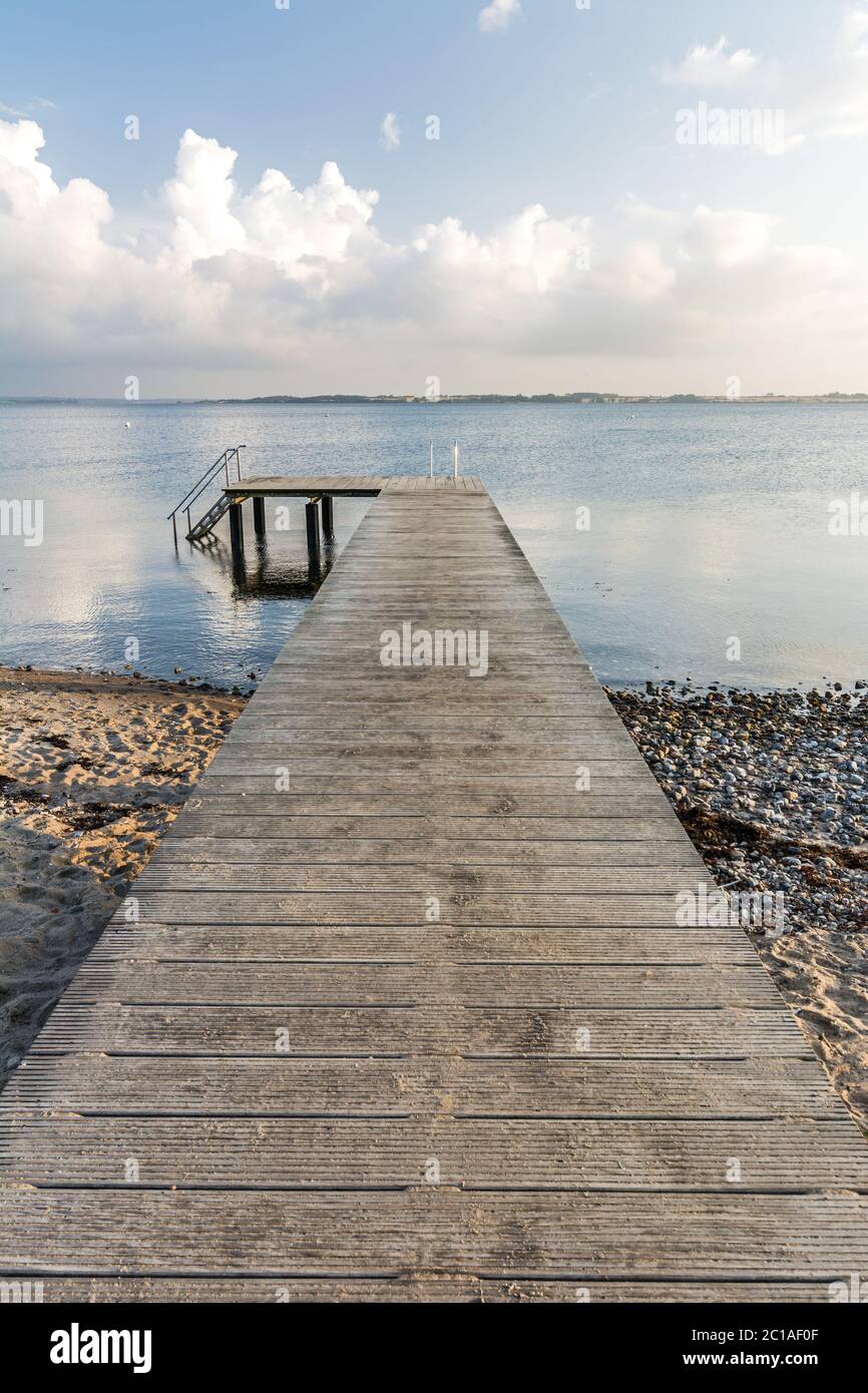 Wooden pier leading towards the ocean Stock Photo - Alamy