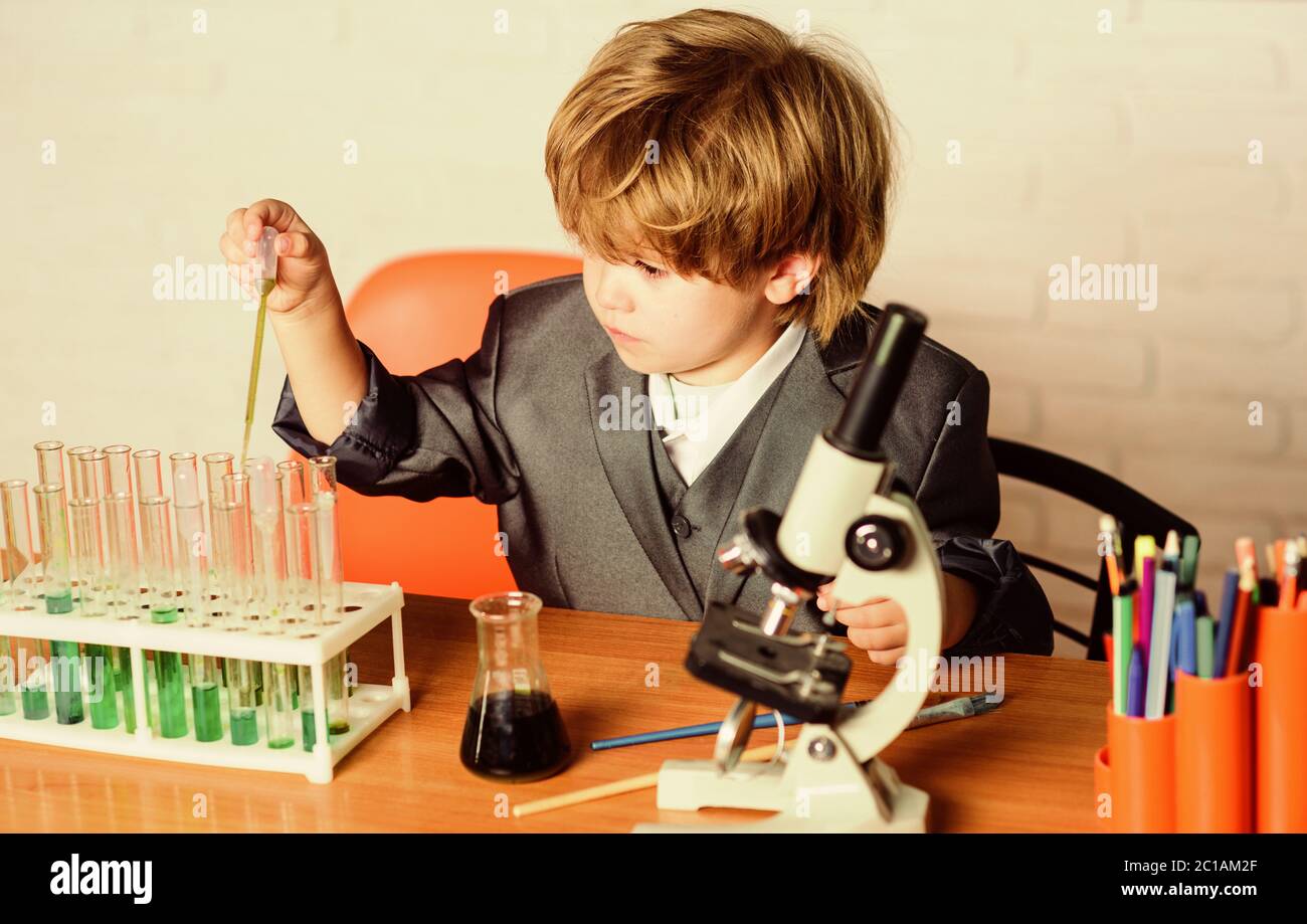 Little kid learning chemistry in school laboratory. kid scientist study ...
