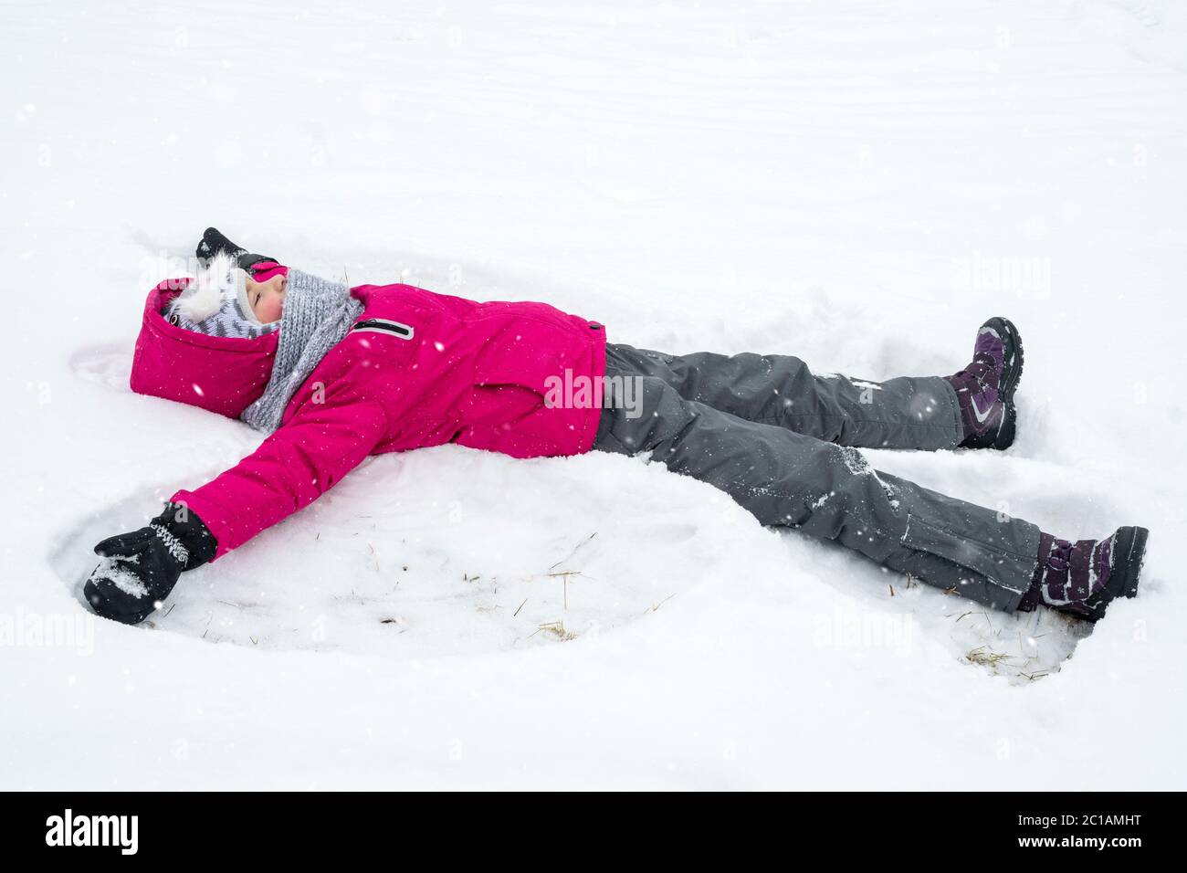 Happy girl making snow angel hi-res stock photography and images - Alamy