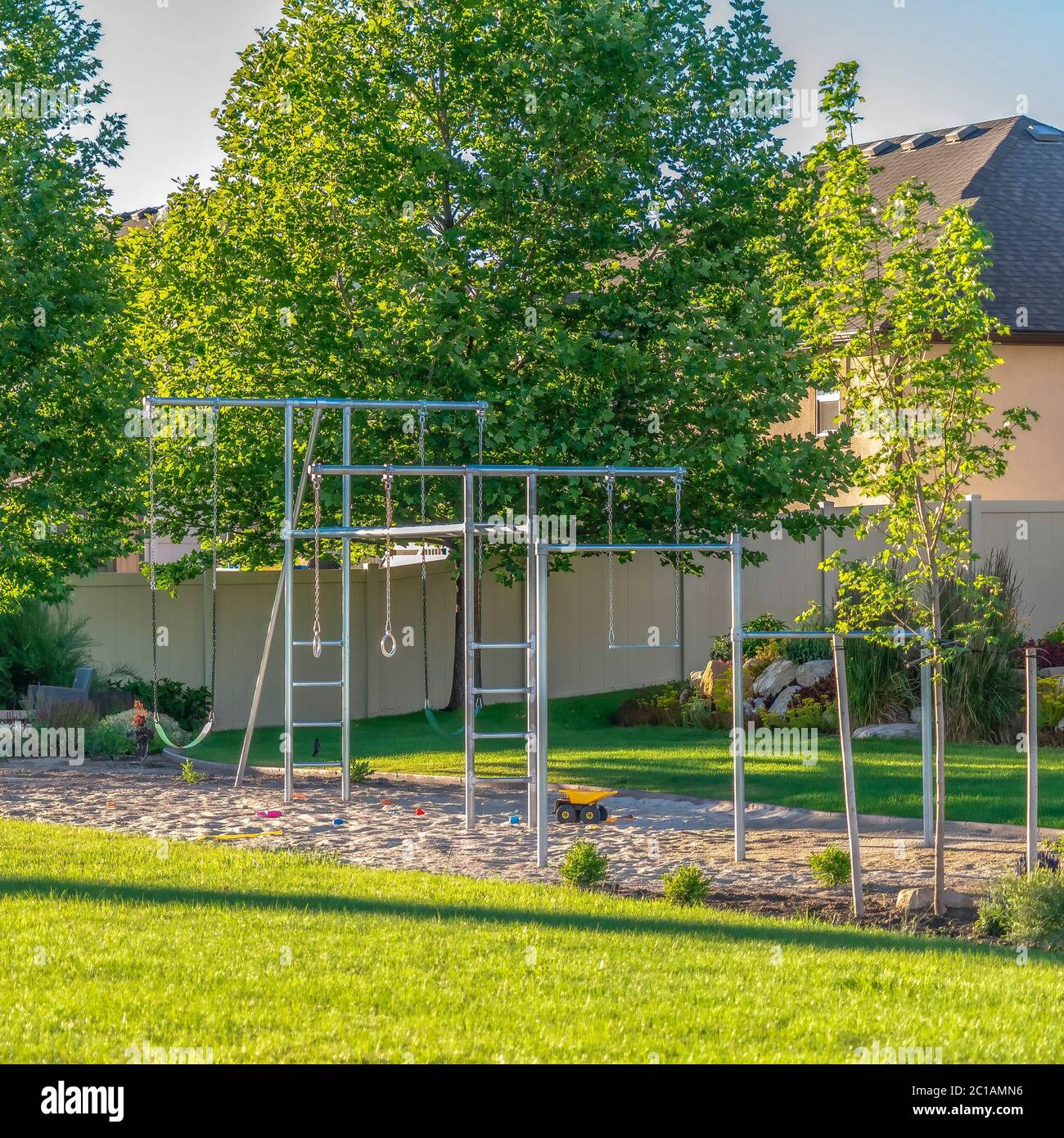 Square Sand playground at the grassy yard of home with climbing bars ...