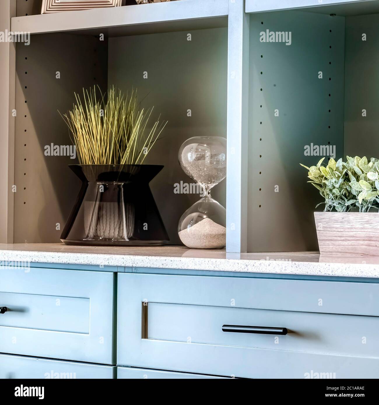 Square crop Close up of cabinet with ornamental plants and hourglass on ...