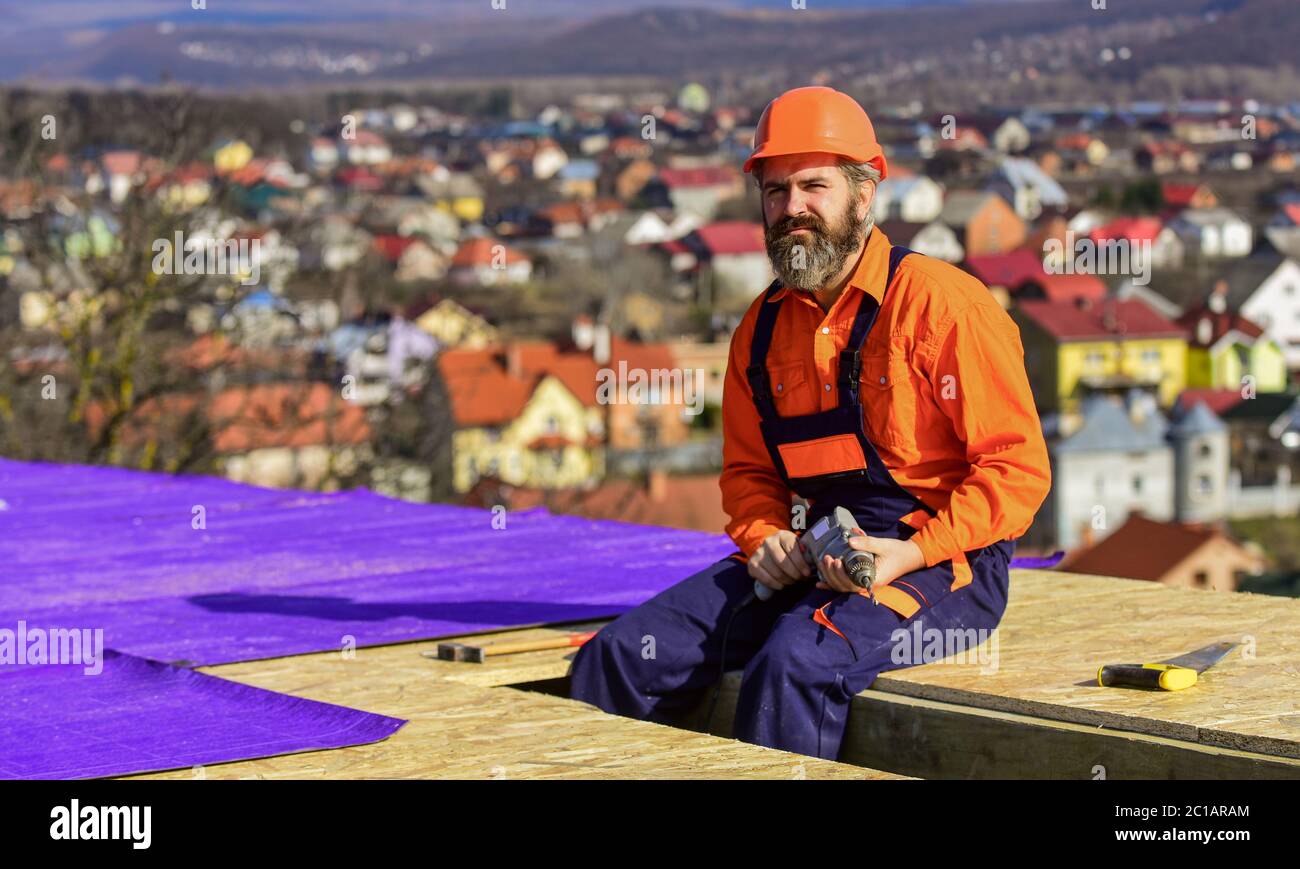 roofer working on roof structure of building on construction site ...