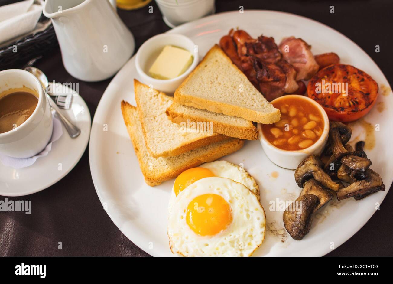 Traditional full English breakfast with fried eggs, bacon, sausages ...