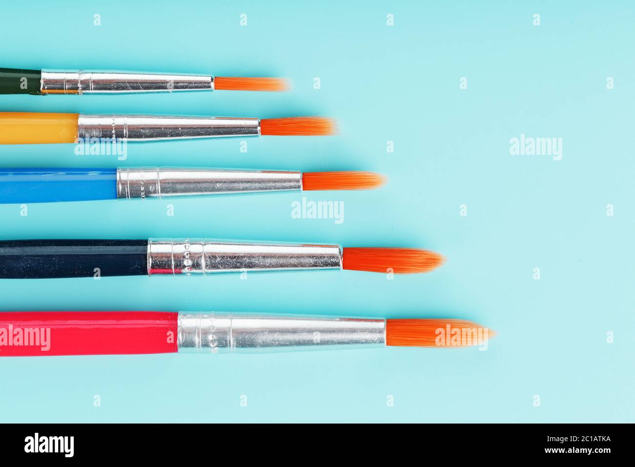 Multi-colored brushes for drawing and art on a blue background Stock ...