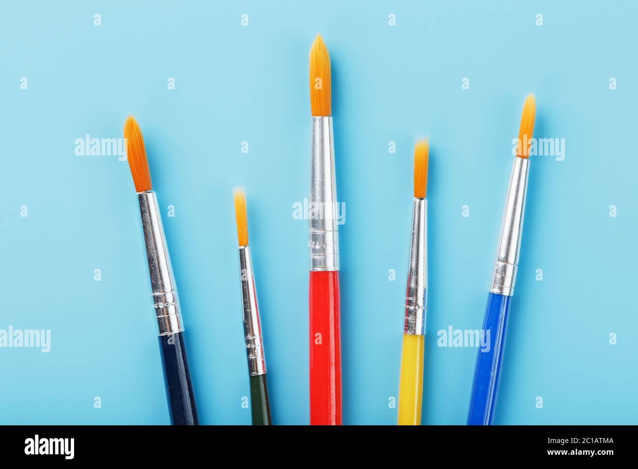 Multi-colored brushes for drawing and art on a blue background Stock ...