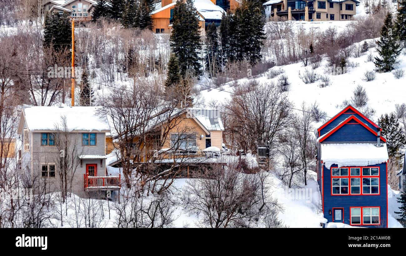 Panorama Colorful homes on hill slope with view of snowy terrain and ...