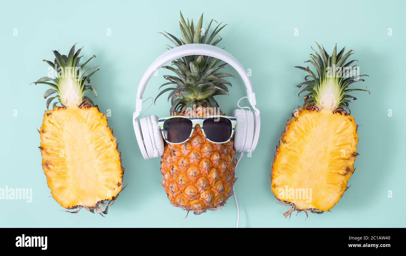 Funny pineapple wearing white headphone, concept of listening music ...