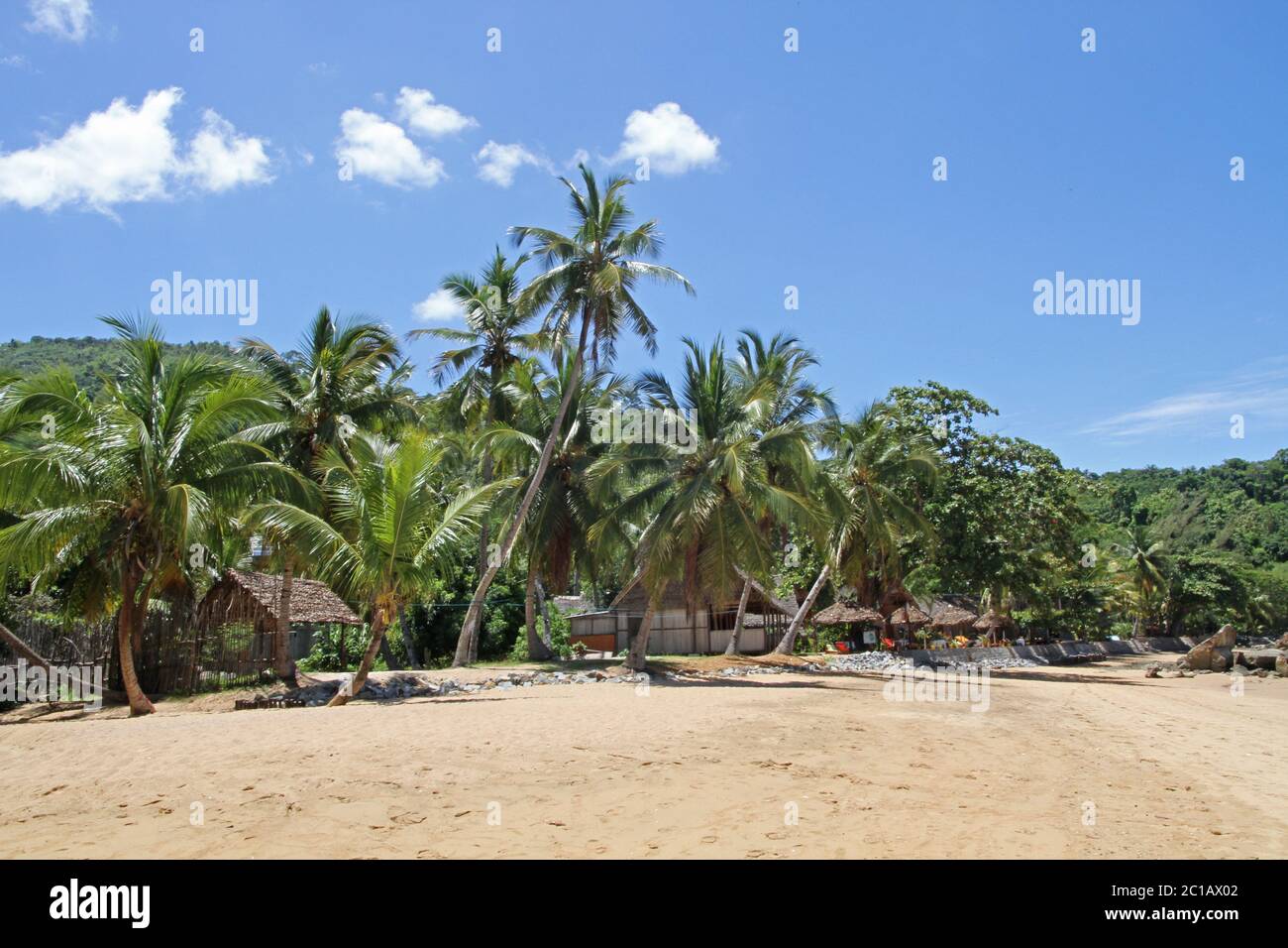 View of beachhouses on beach with palm trees, Ampangorinana Village ...