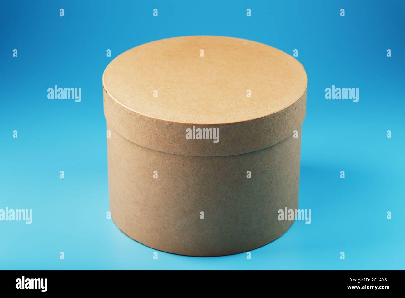 Round cardboard box on a blue background, free space Stock Photo - Alamy