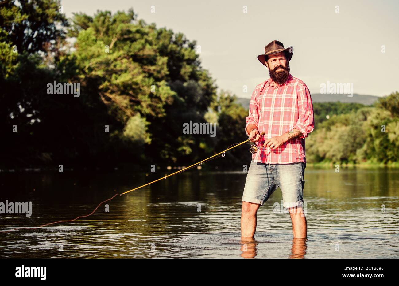 Man at riverside enjoy idyllic landscape while fishing. Environmental ...