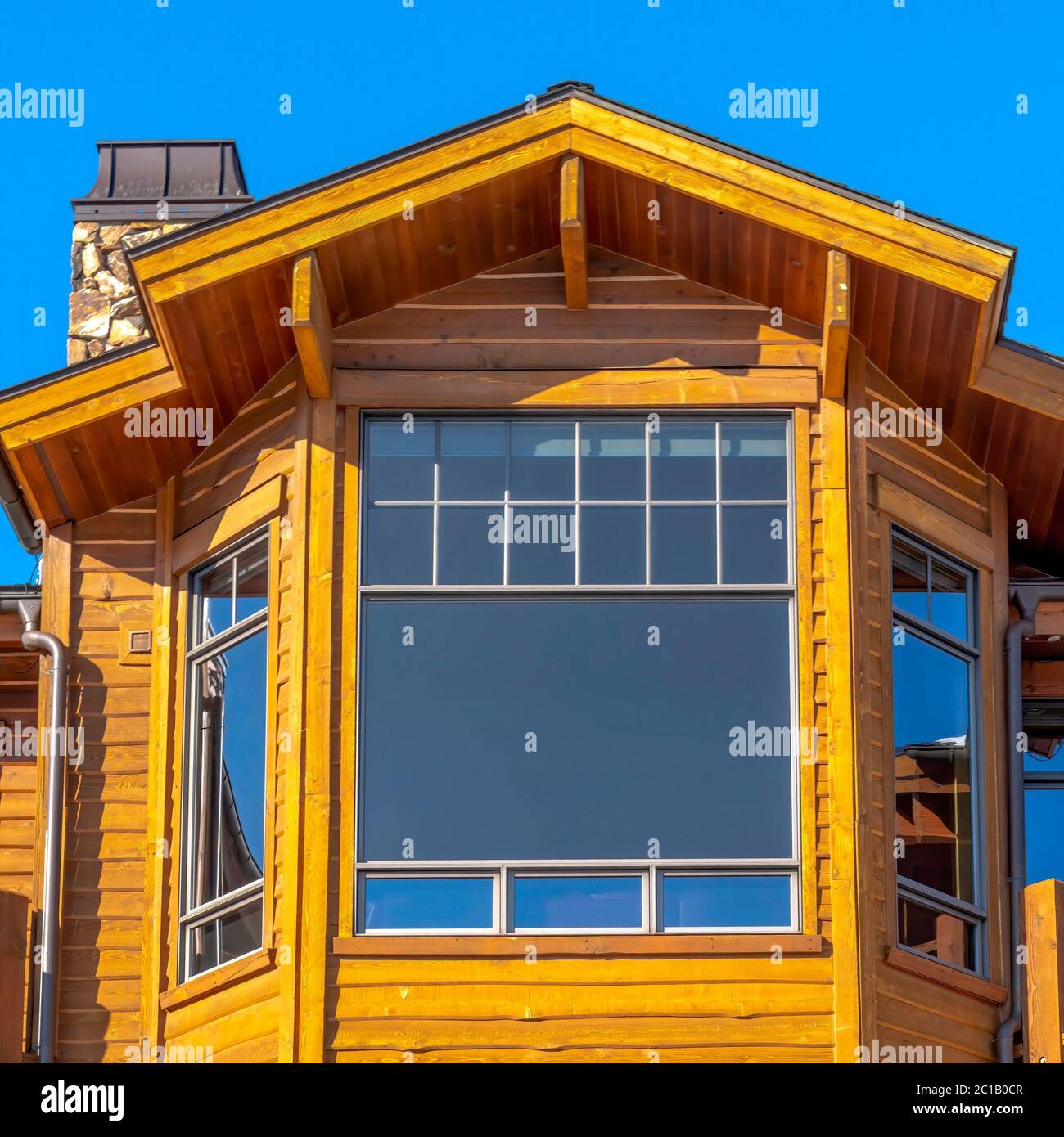 Square Multi storey home facade with large bay windows and wooden ...