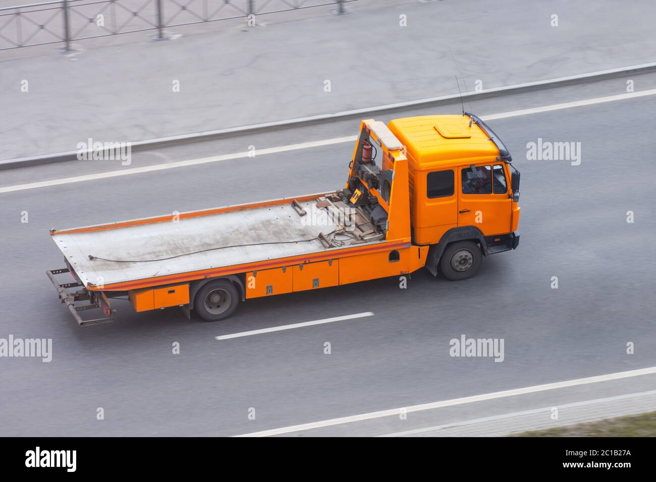 Empty tow truck rides on the highway Stock Photo - Alamy