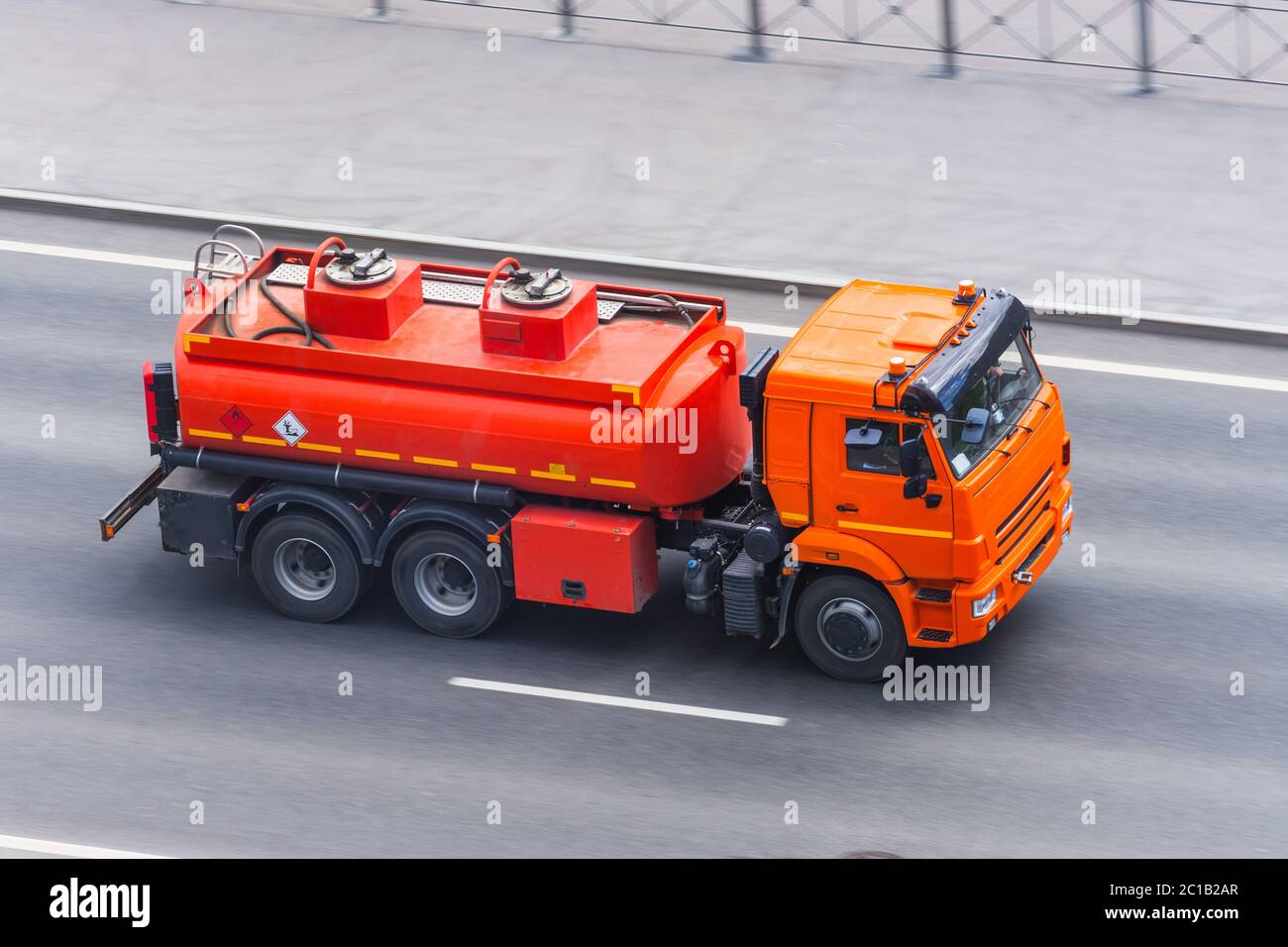 A bright orange truck with a tank for combustible fuel and other ...