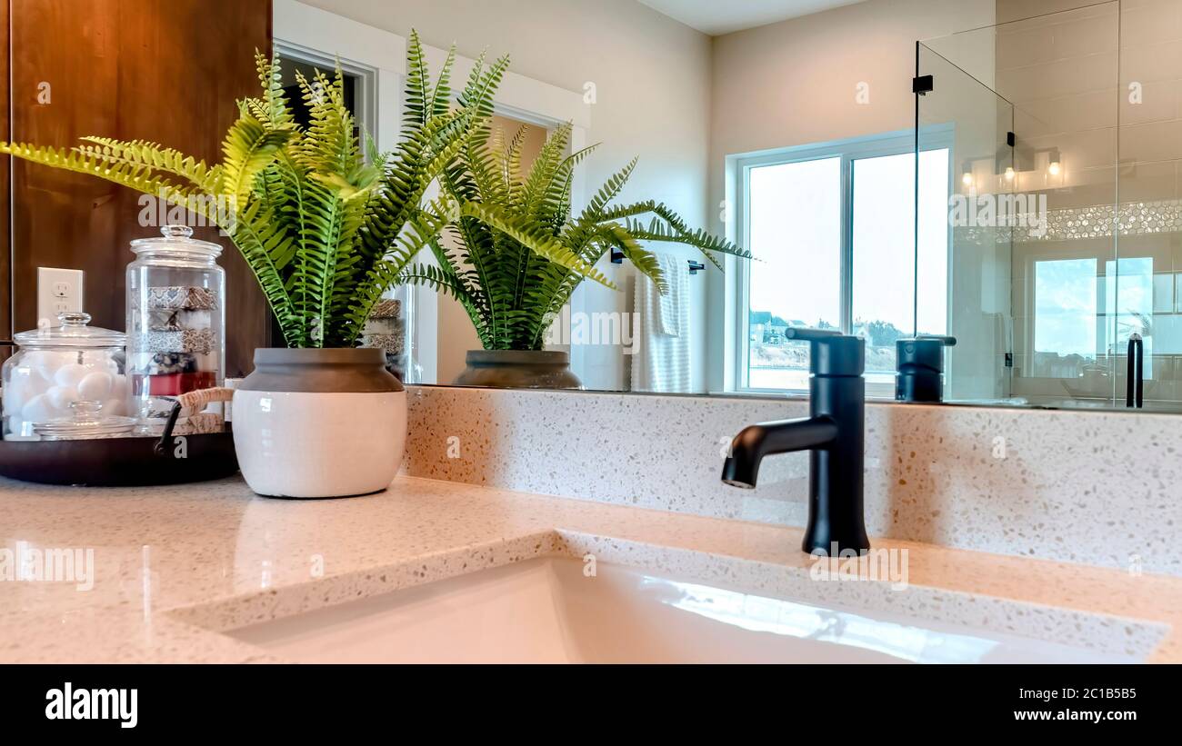 Panorama crop Sink and faucet against mirror that reflects shower stall ...