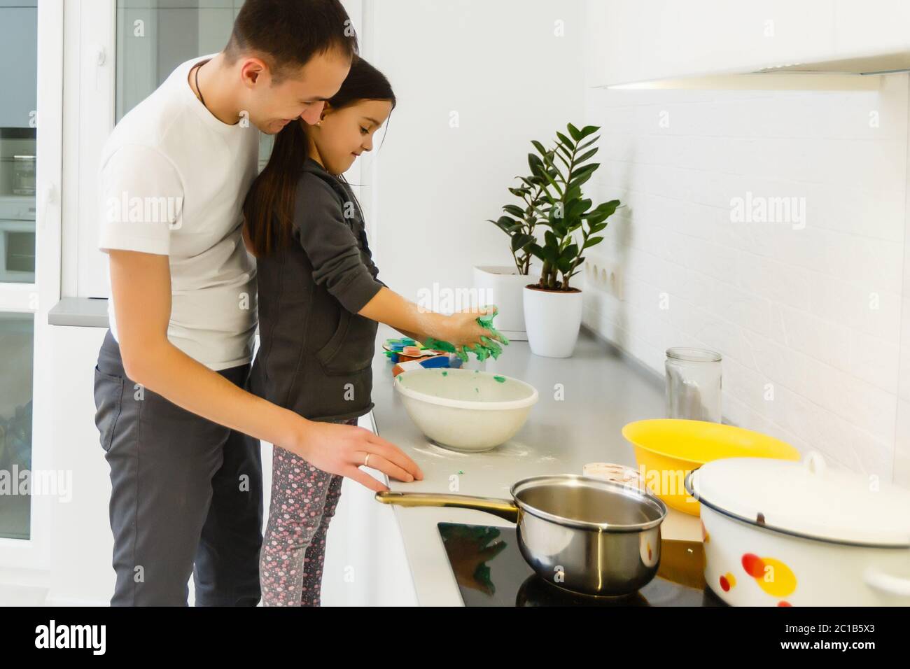 Father and daughter making meal together in kitchen. Cooking classes ...
