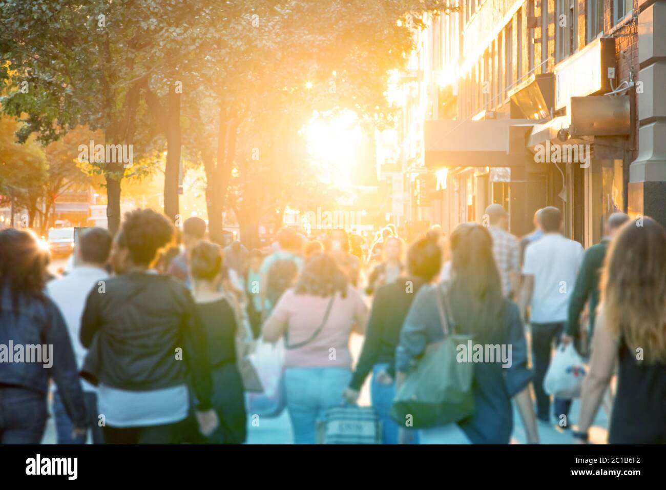 Crowd of anonymous people walking down the sidewalk on a busy street in ...