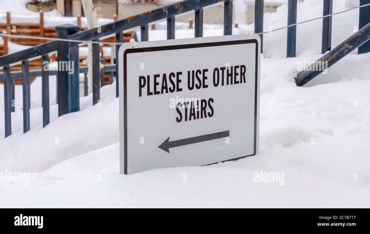 Panorama crop Stairs buried in winter snow with sign that reads Please ...