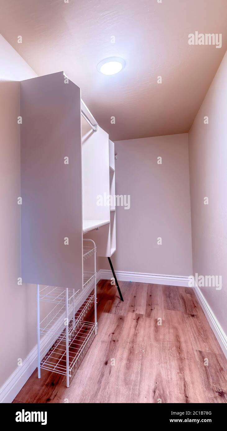 Vertical crop Walk in closet with metal rod and shelves on the wall ...