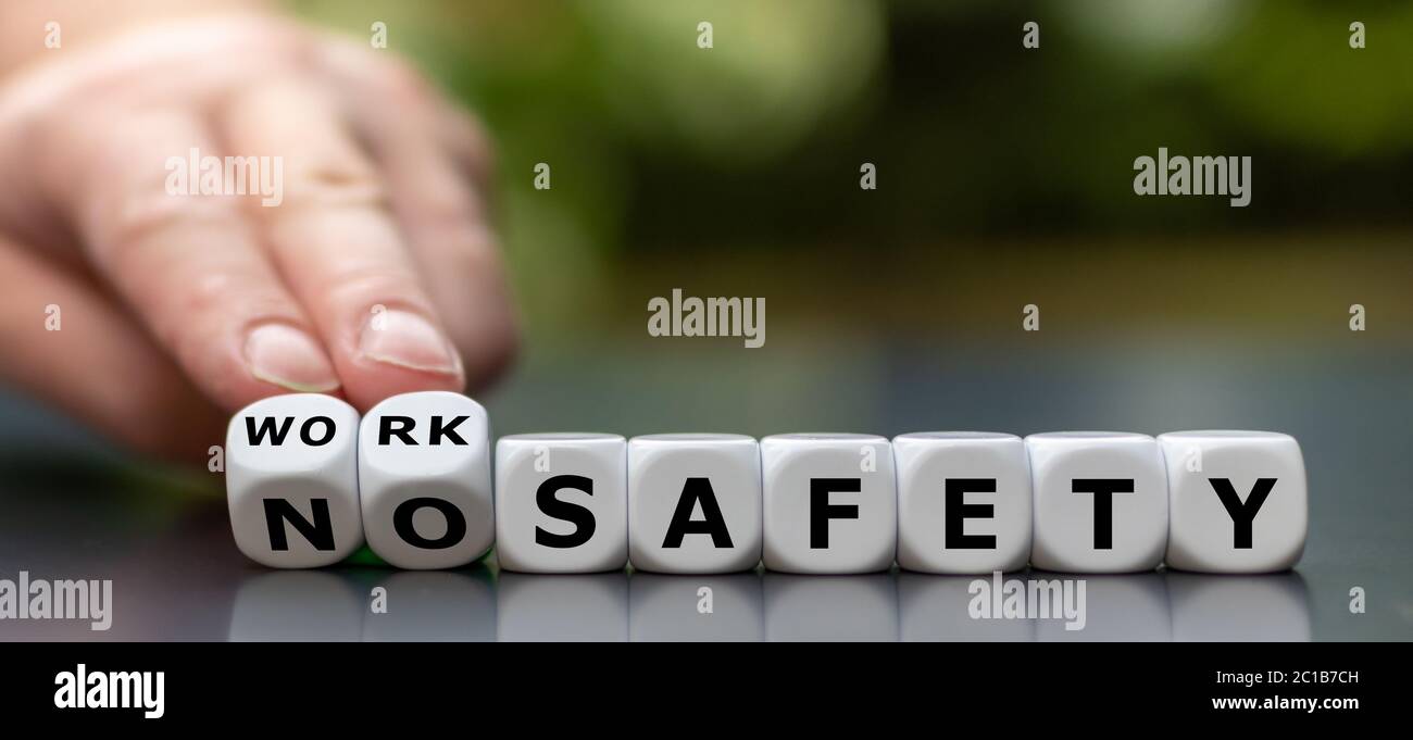 Hand turns dice and changes the expression "no safety" to "work safety ...