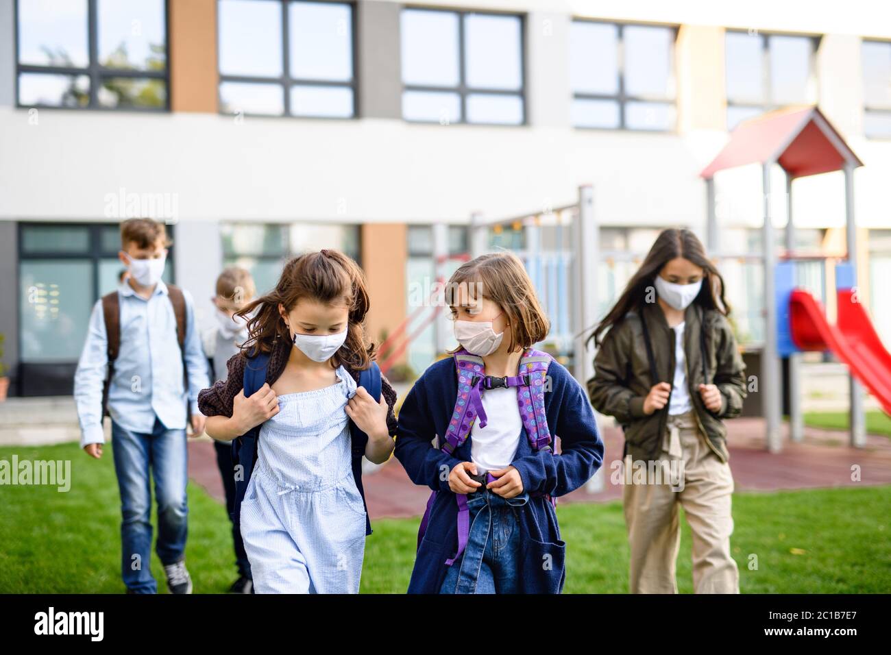 Children with face mask going back to school after covid-19 lockdown ...
