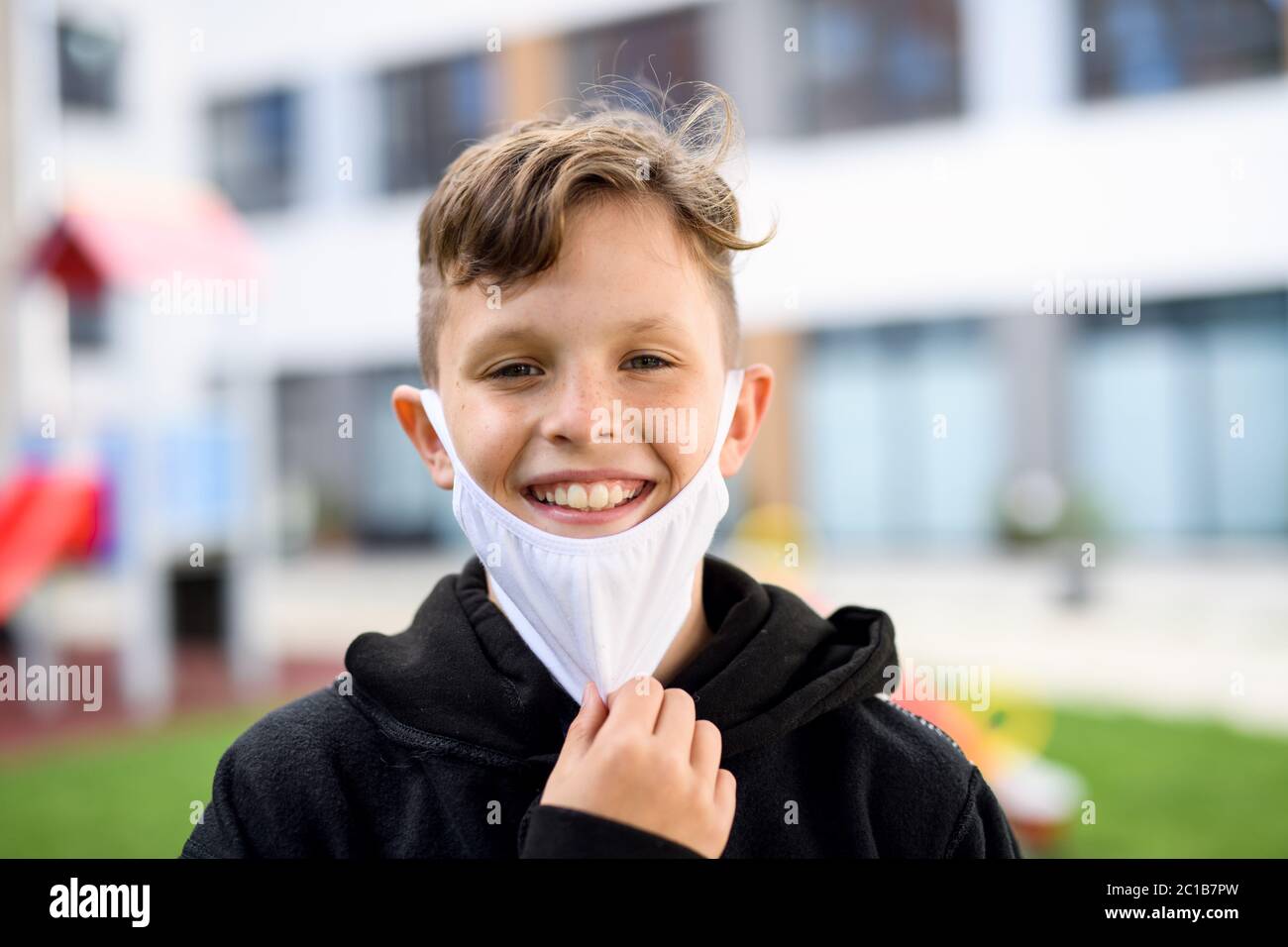 Portrait of happy boy with face mask going back to school after covid ...