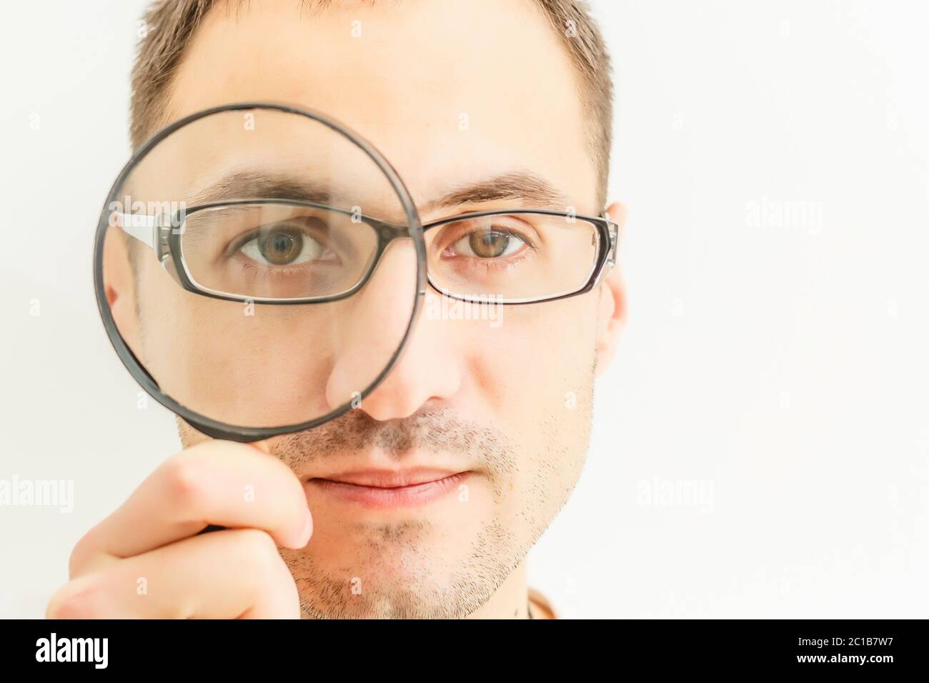 Man looking through a magnifying glass isolated on white background ...