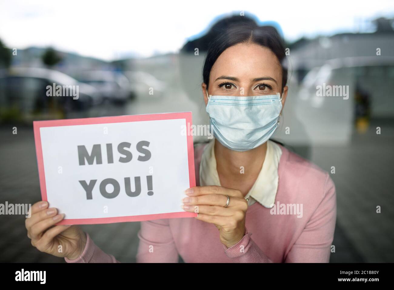 Portrait of teacher with face mask after lockdown, holding miss you ...