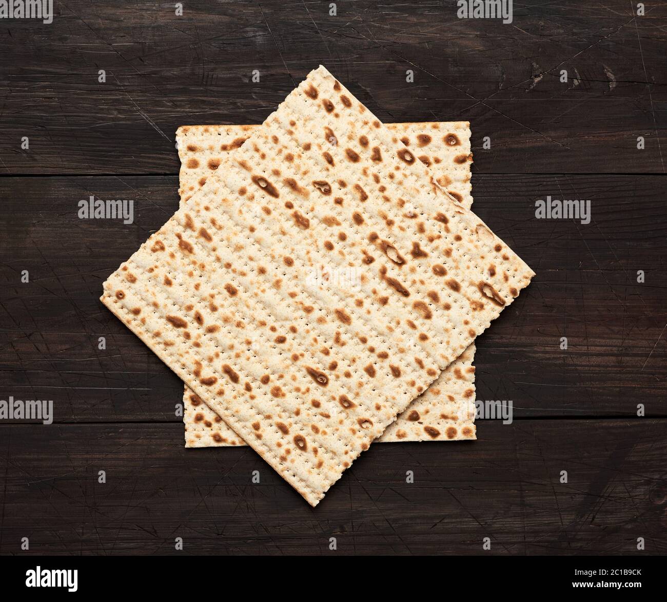 stack of baked square matzo on a brown wooden background, top view ...