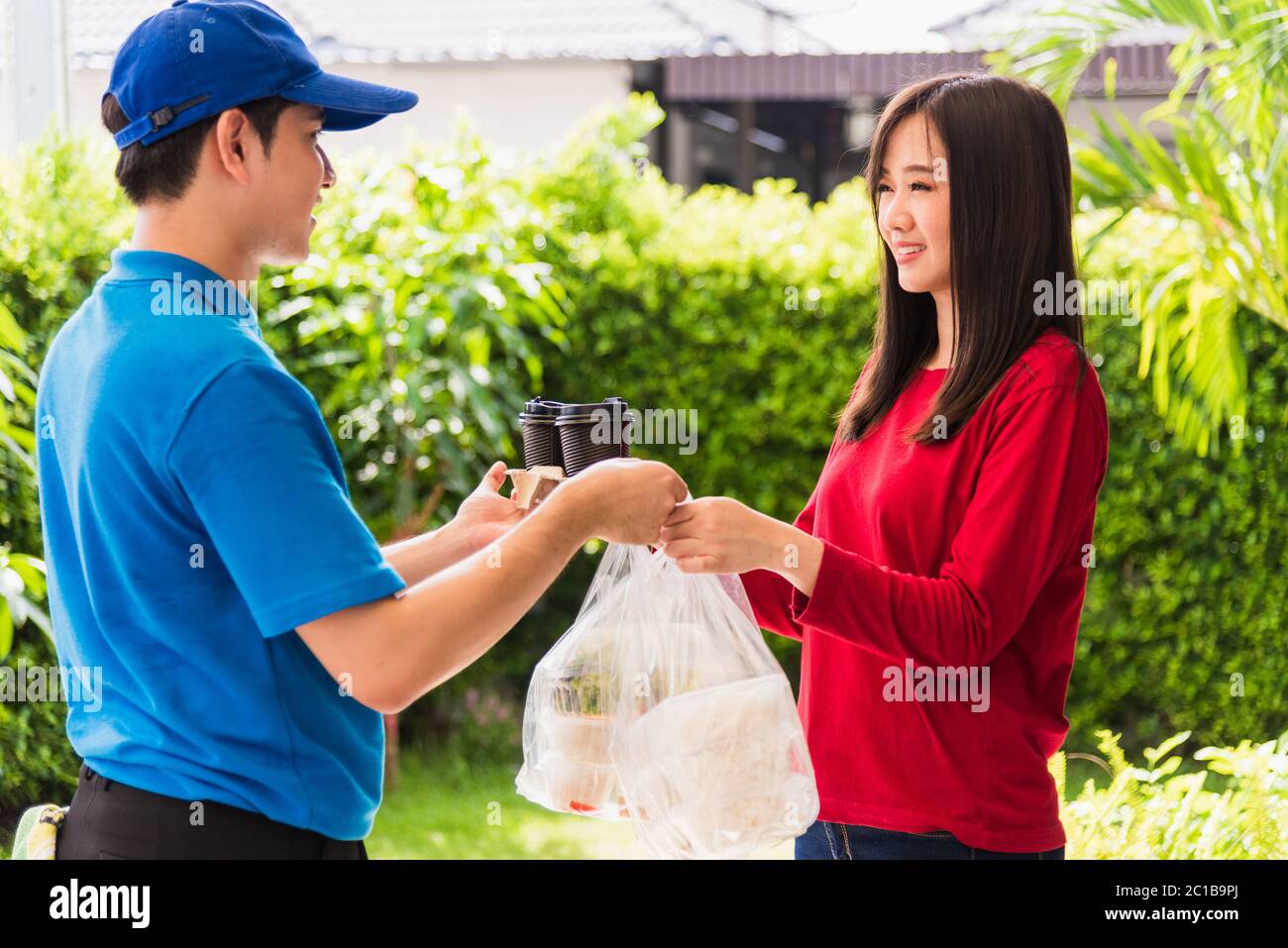 Asian young delivery man in blue uniform he making grocery service ...