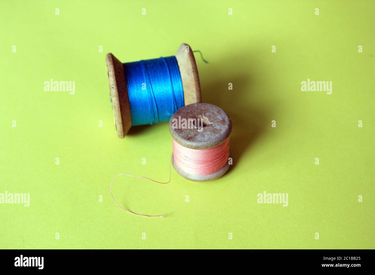 cotton thread reels bobbin pink and blue on bright background with copy ...