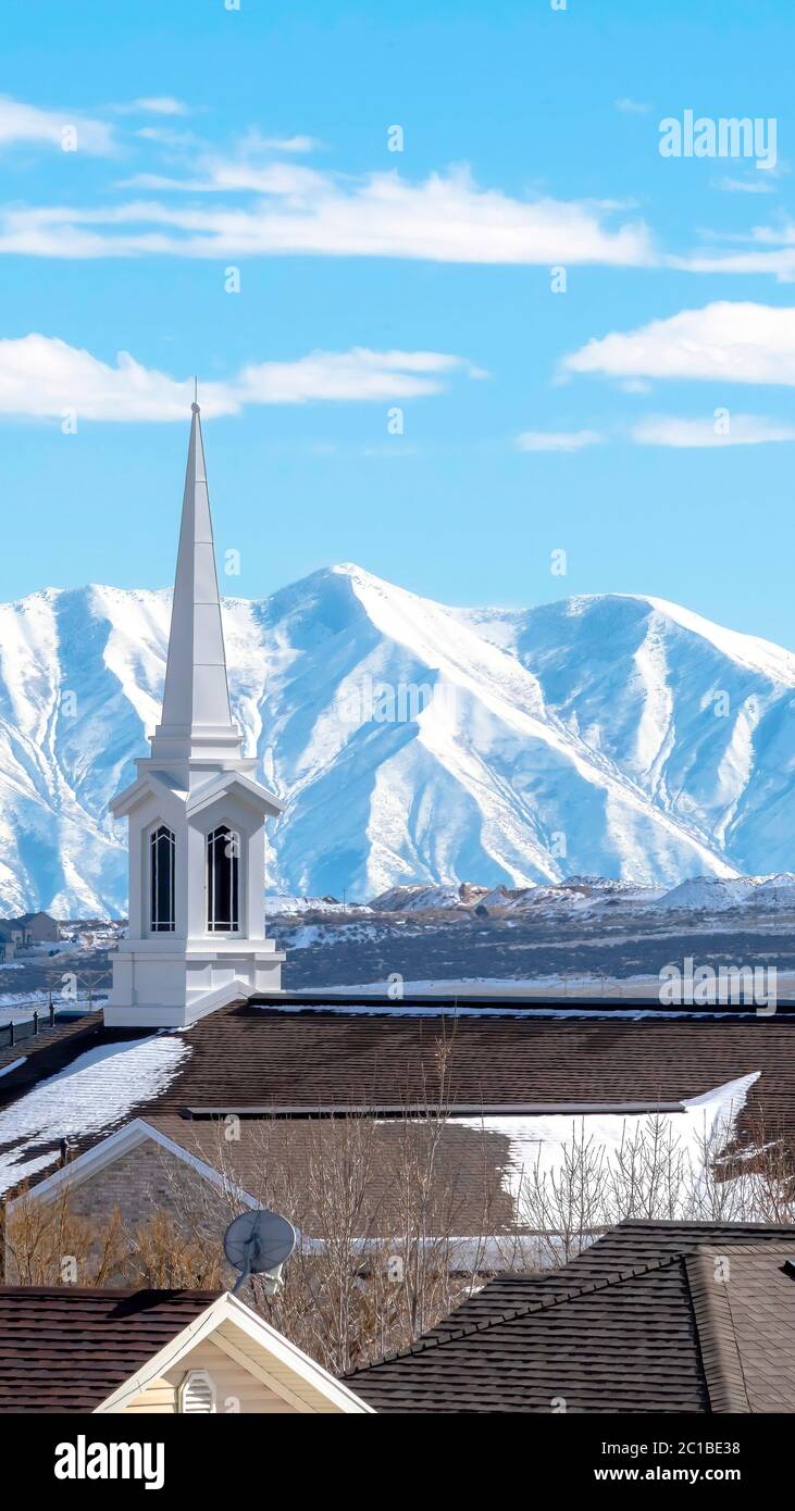 Vertical Modern spires of church with steep snowy mountain and sunny ...