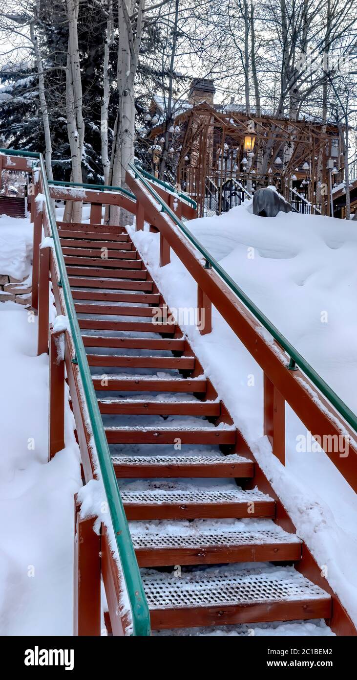Vertical frame Outdoor stairs on snowy slope against buildings and ...