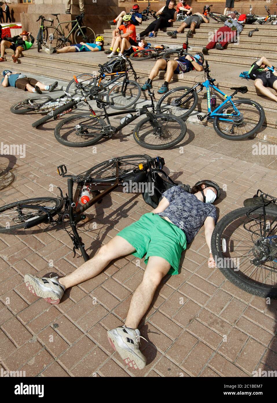 A cyclist lays on the ground with his bike during the protest.Cyclists ...