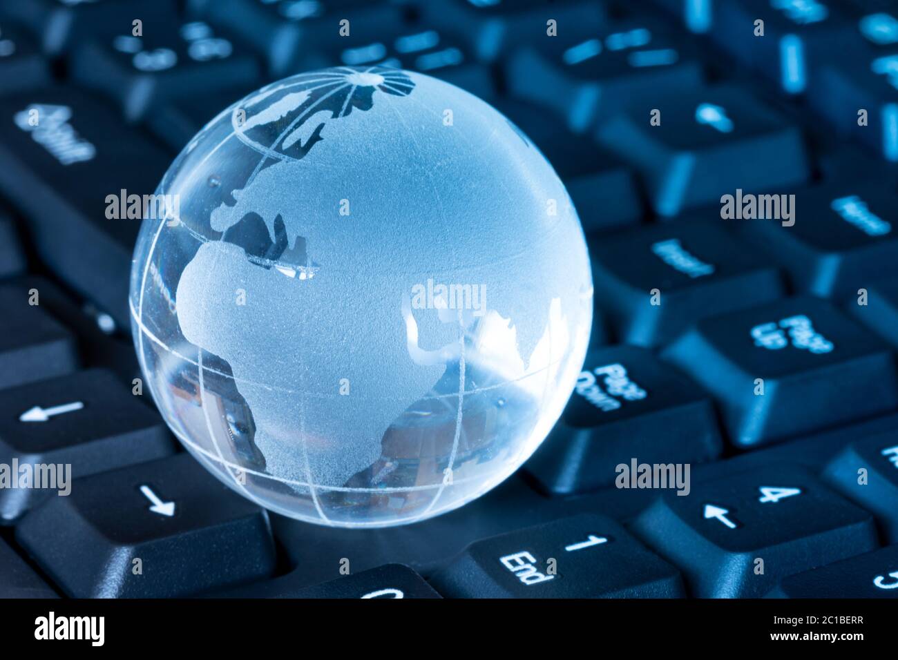 Glass globe on the keyboard Stock Photo - Alamy
