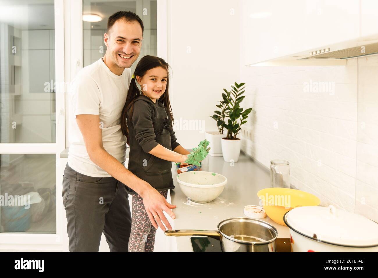 Father and daughter making meal together in kitchen. Cooking classes ...