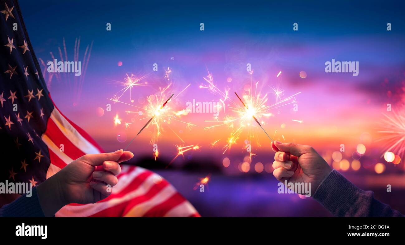 Usa Celebration - Hands Holding Sparklers And American Flag At Sunset ...