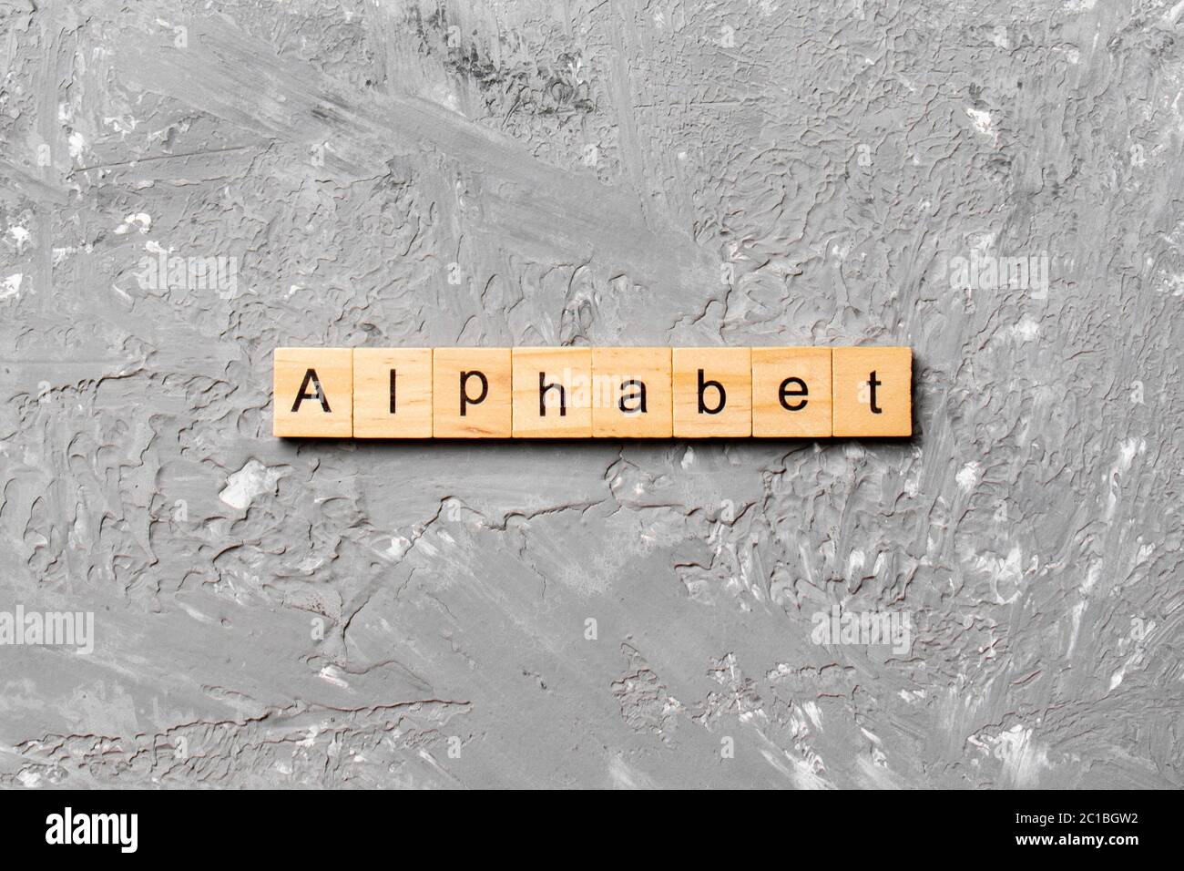 alphabet word written on wood block. alphabet text on cement table for ...