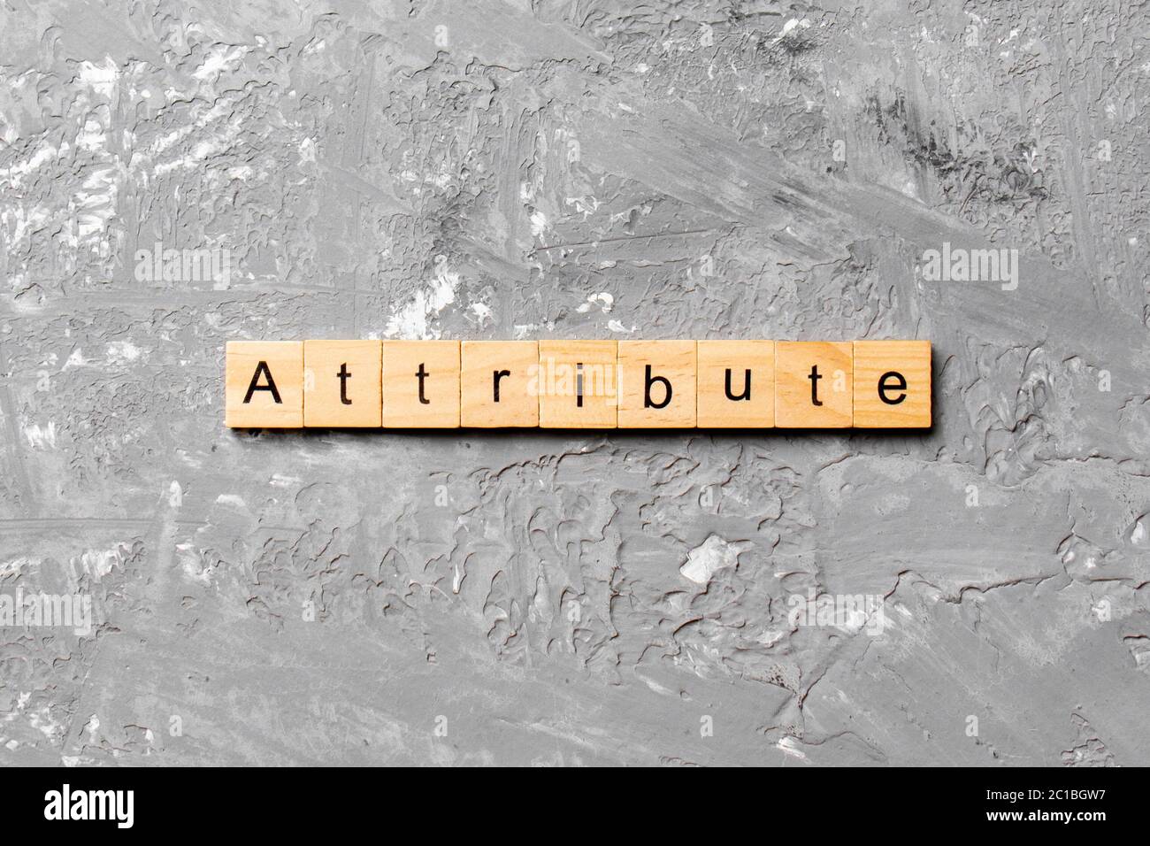 ATTRIBUTE word written on wood block. ATTRIBUTE text on cement table ...