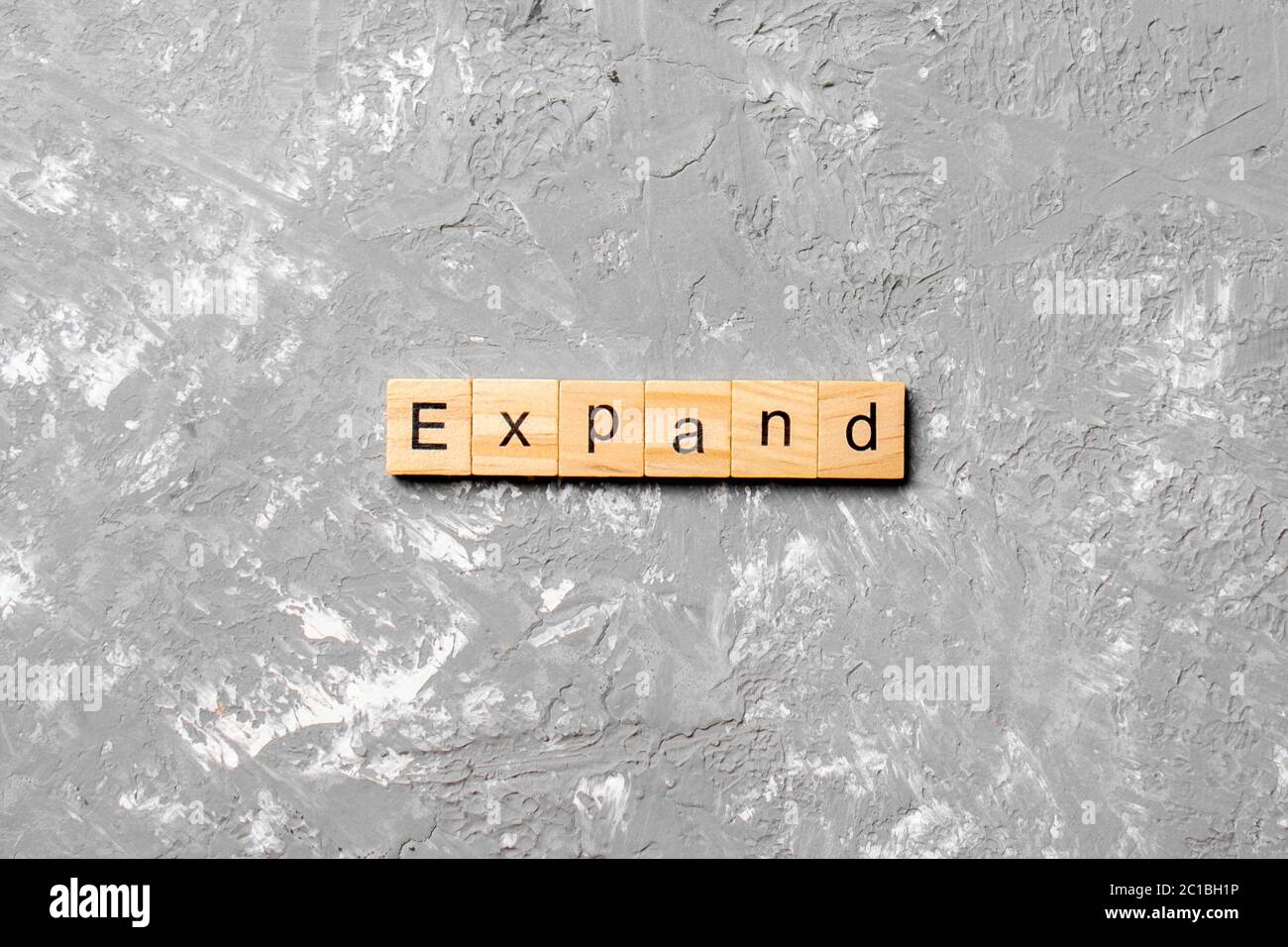 EXPAND word written on wood block. EXPAND text on cement table for your desing, concept Stock ...