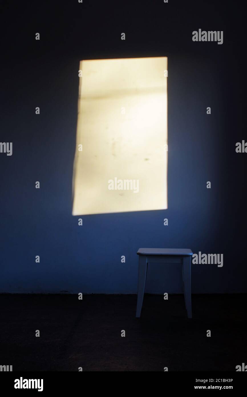 white stool and rectangular light from the window in a dark photo ...