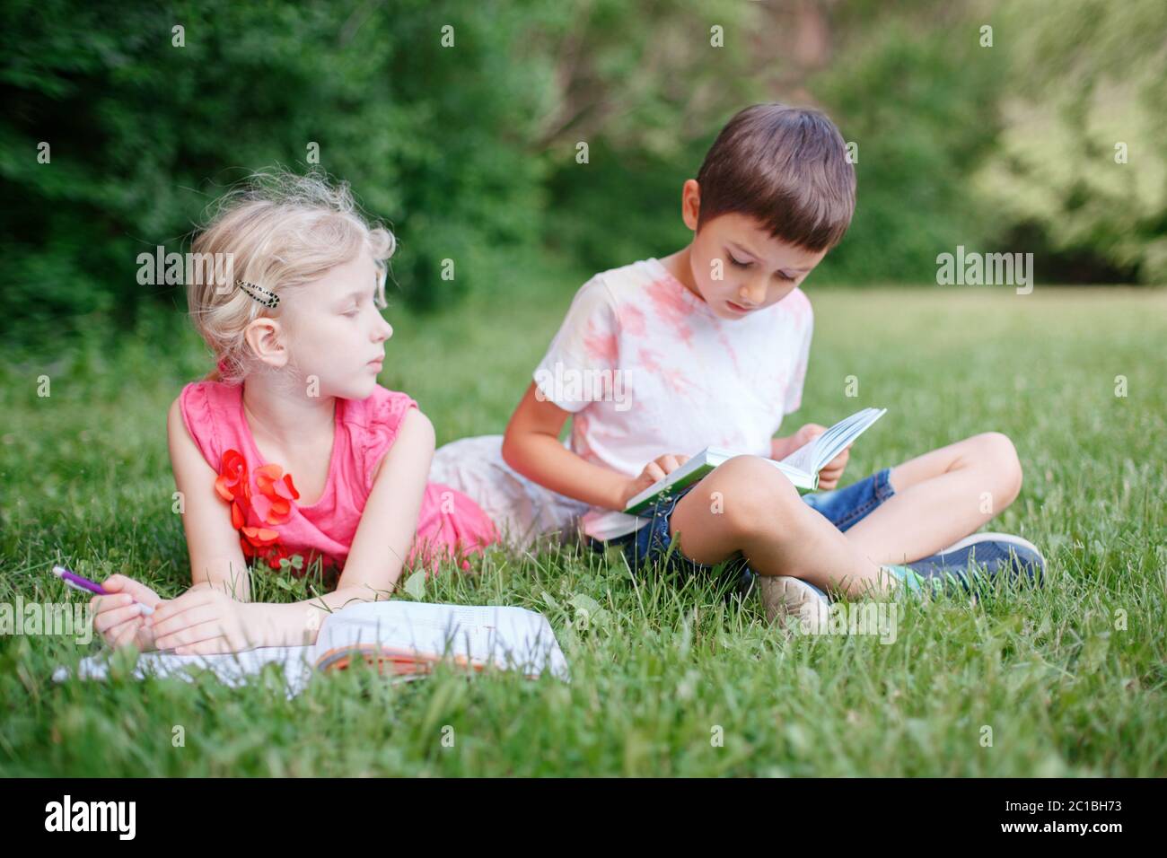 Young Caucasian school girl and boy friends doing school homework in ...