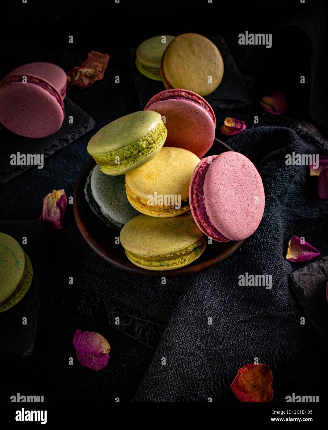 Classic coclorful French macarons on black background, still life Stock ...